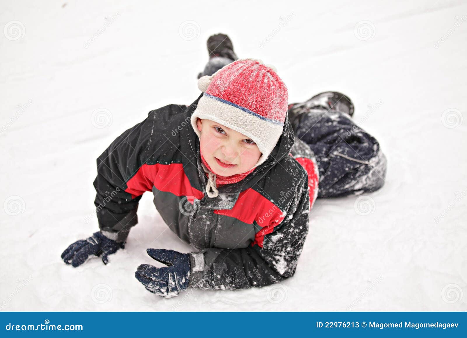 Boy laying down on snow stock image. Image of winter - 22976213