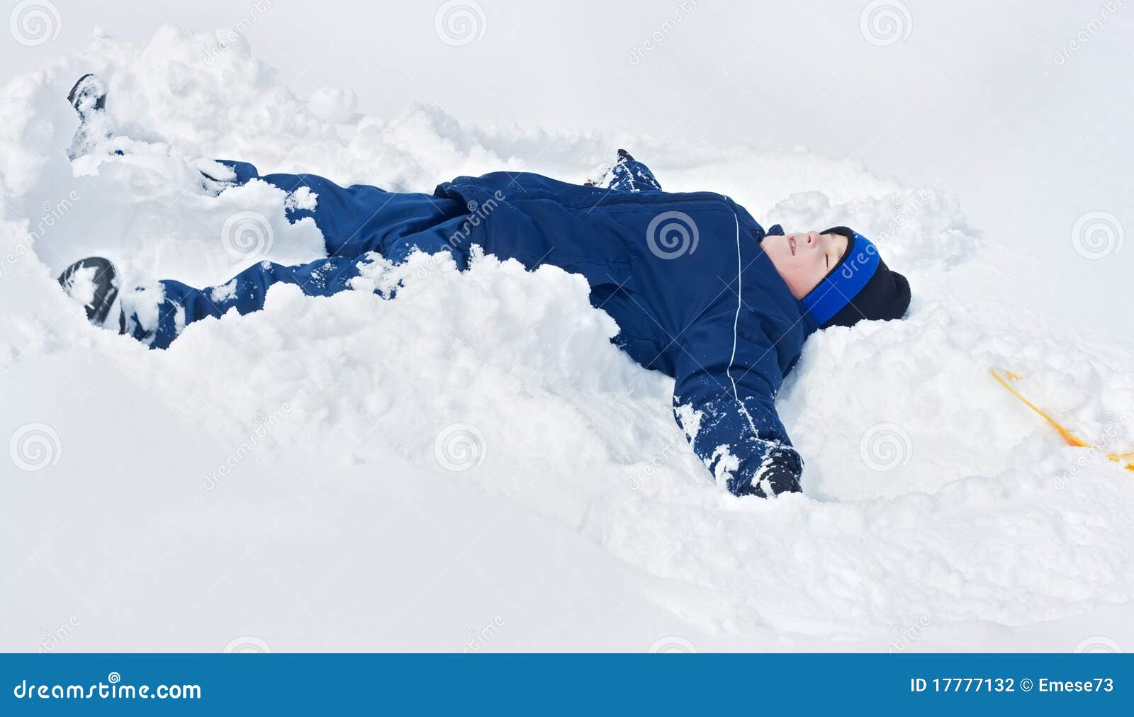 Boy laying in the snow stock photo. Image of recreation - 17777132