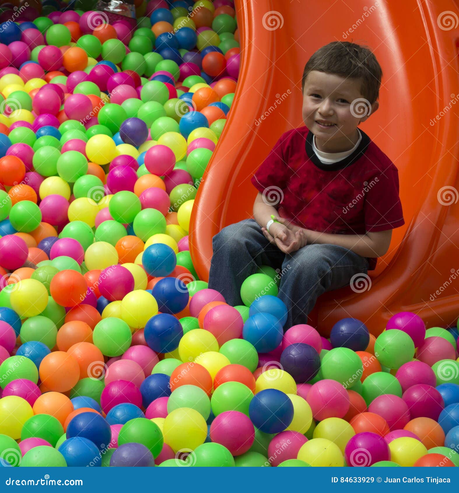 Boy Lays on the Big Heap of Multicolored Small Balls. Stock Image ...