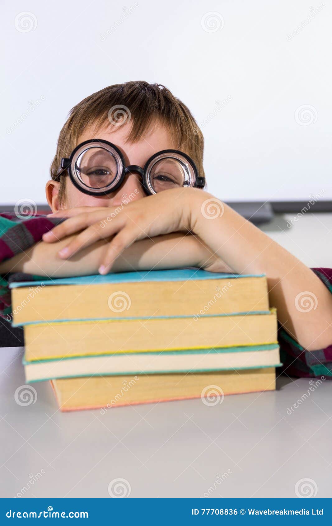 Boy Leaning on Books at Table in Classroom Stock Photo - Image of focus ...