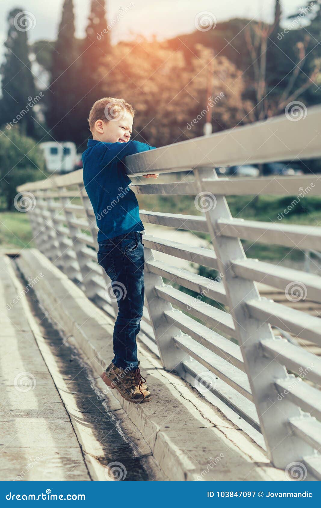 Boy Leaning Over a Bridge Railing Looking Down at River Stock Image ...