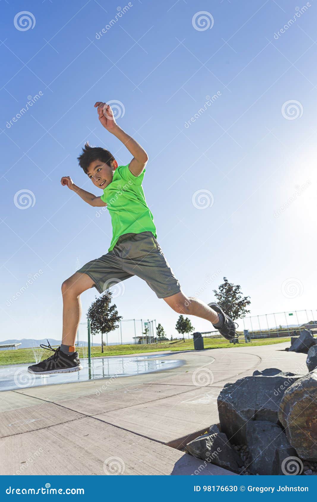 Boy leaping off a rock. stock photo. Image of life, freedom - 98176630