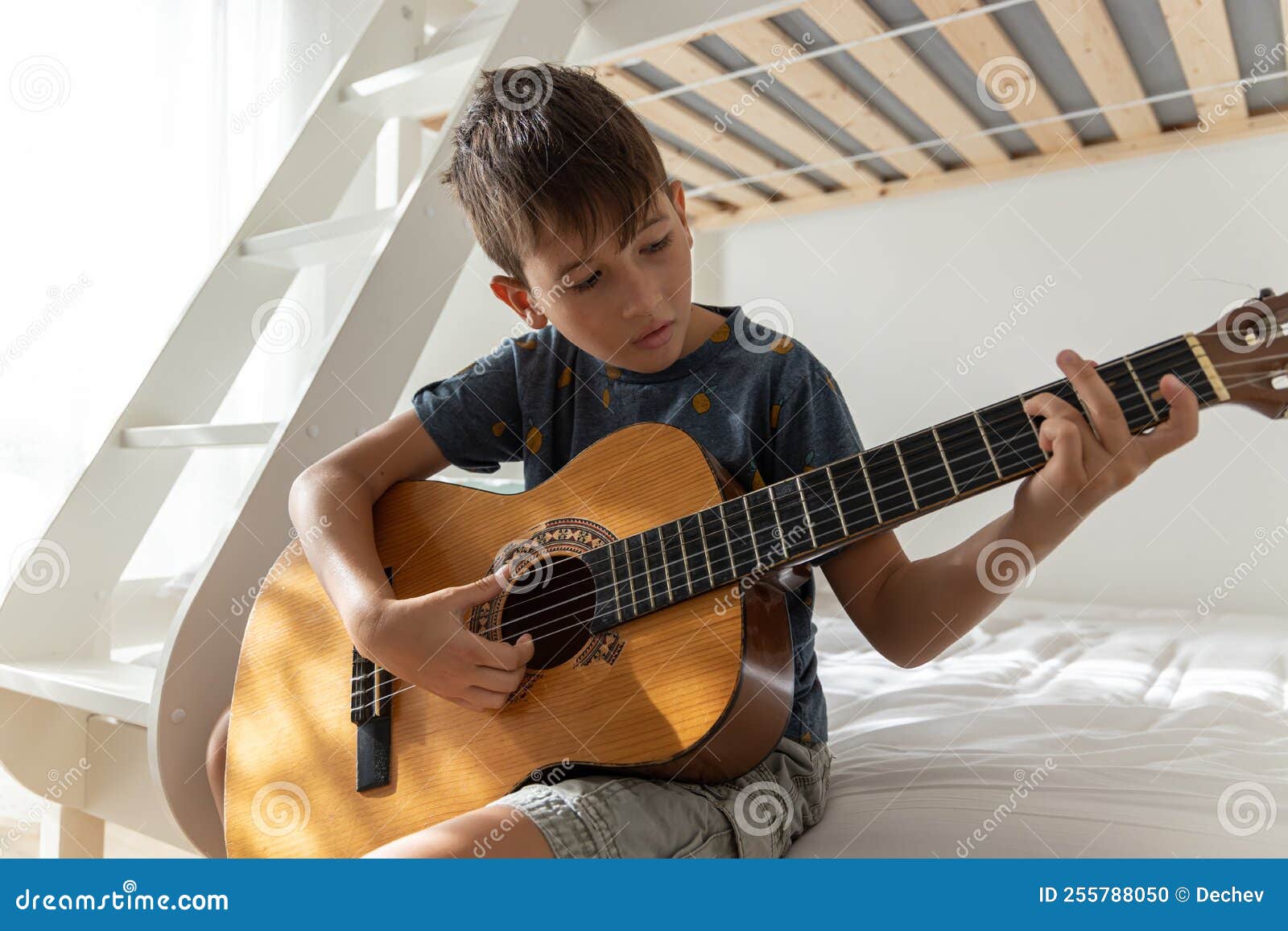 Boy Learning To Play Acoustic Guitar. Boy is Practicing Acoustic Guitar ...