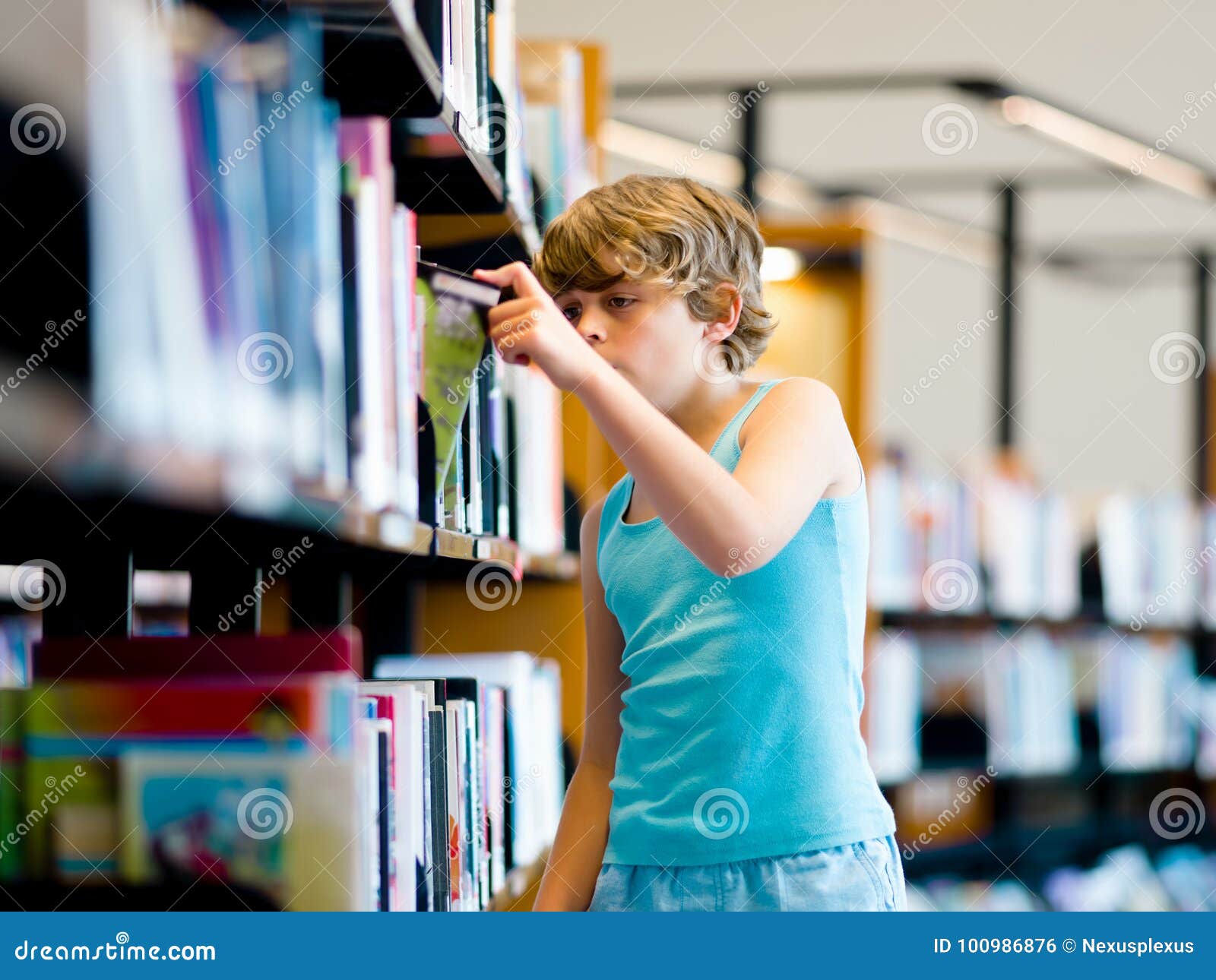 Boy in library stock photo. Image of casual, friend - 100986876