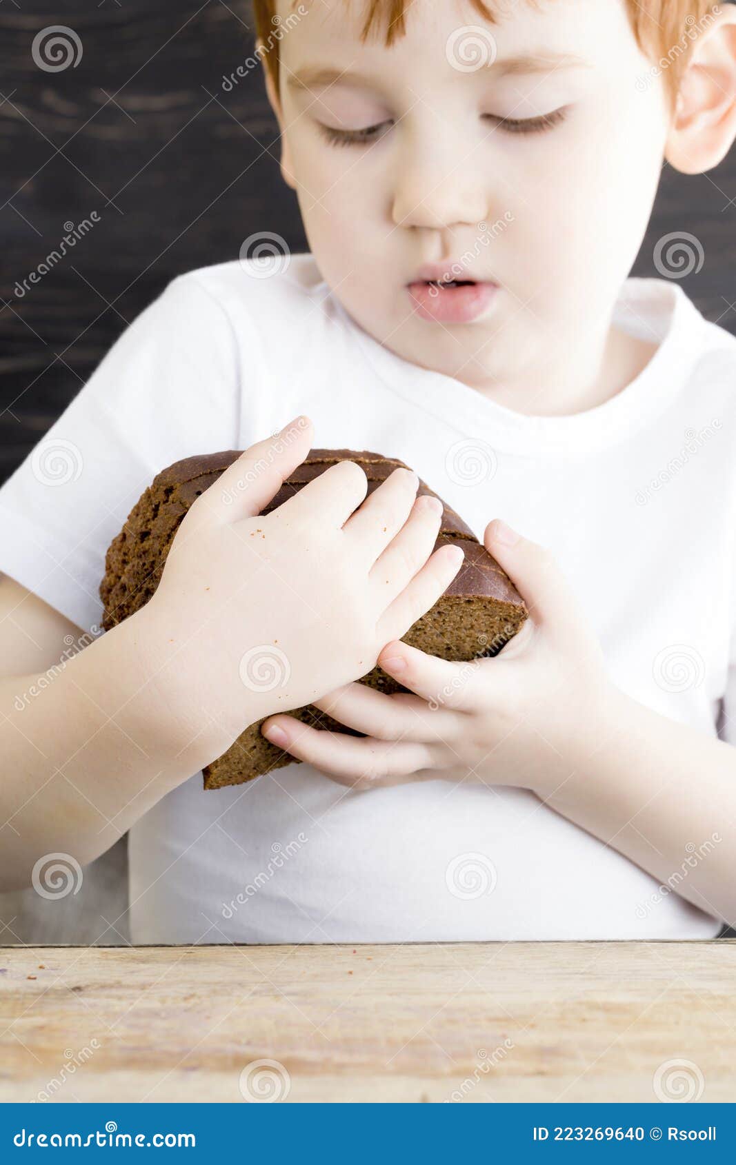 Boy with a loaf of bread stock photo. Image of redhaired - 223269640