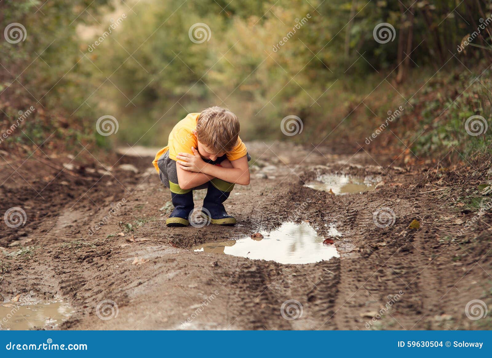 Boy Look into the Puddle on the Country Road Stock Photo - Image of ...