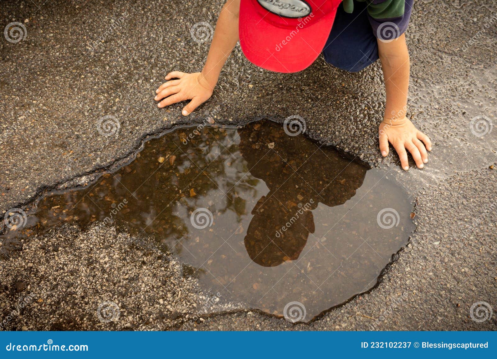 A Boy Looking at His Reflection in a Rain Puddle Stock Image - Image of ...