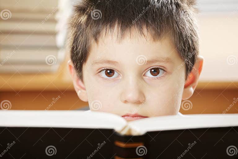 Boy looking over book stock image. Image of desk, book - 26461735