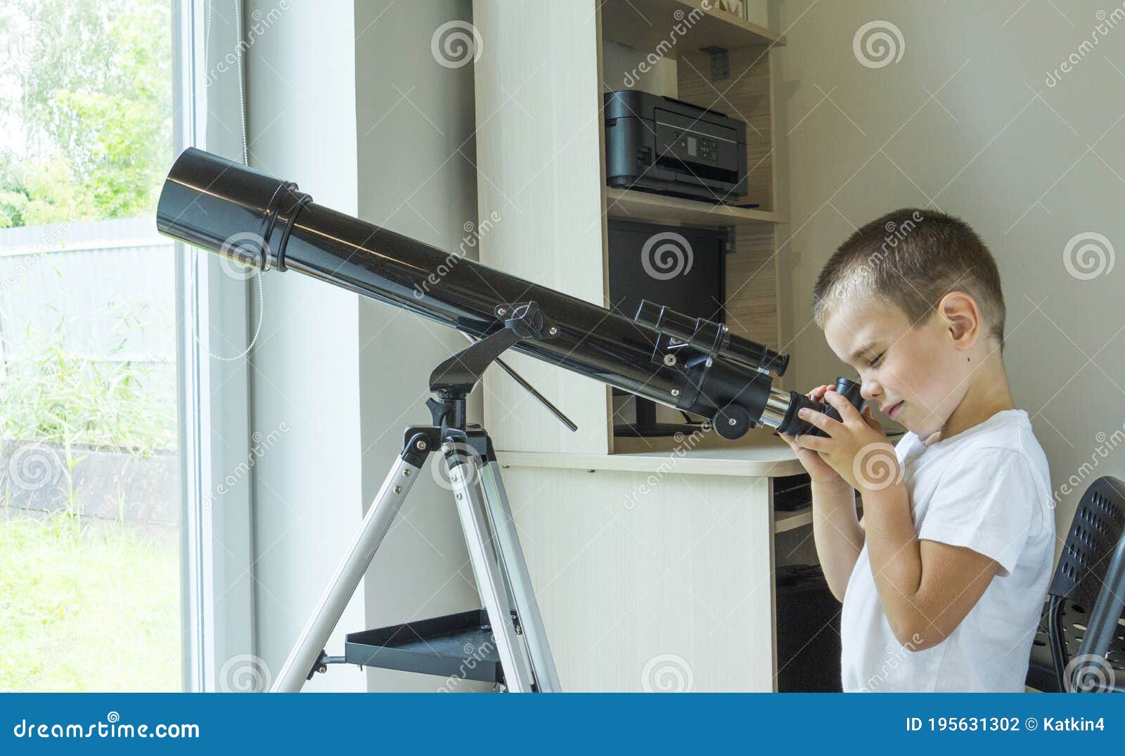 A Boy Looking through a Telescope Indoors Stock Photo - Image of ...