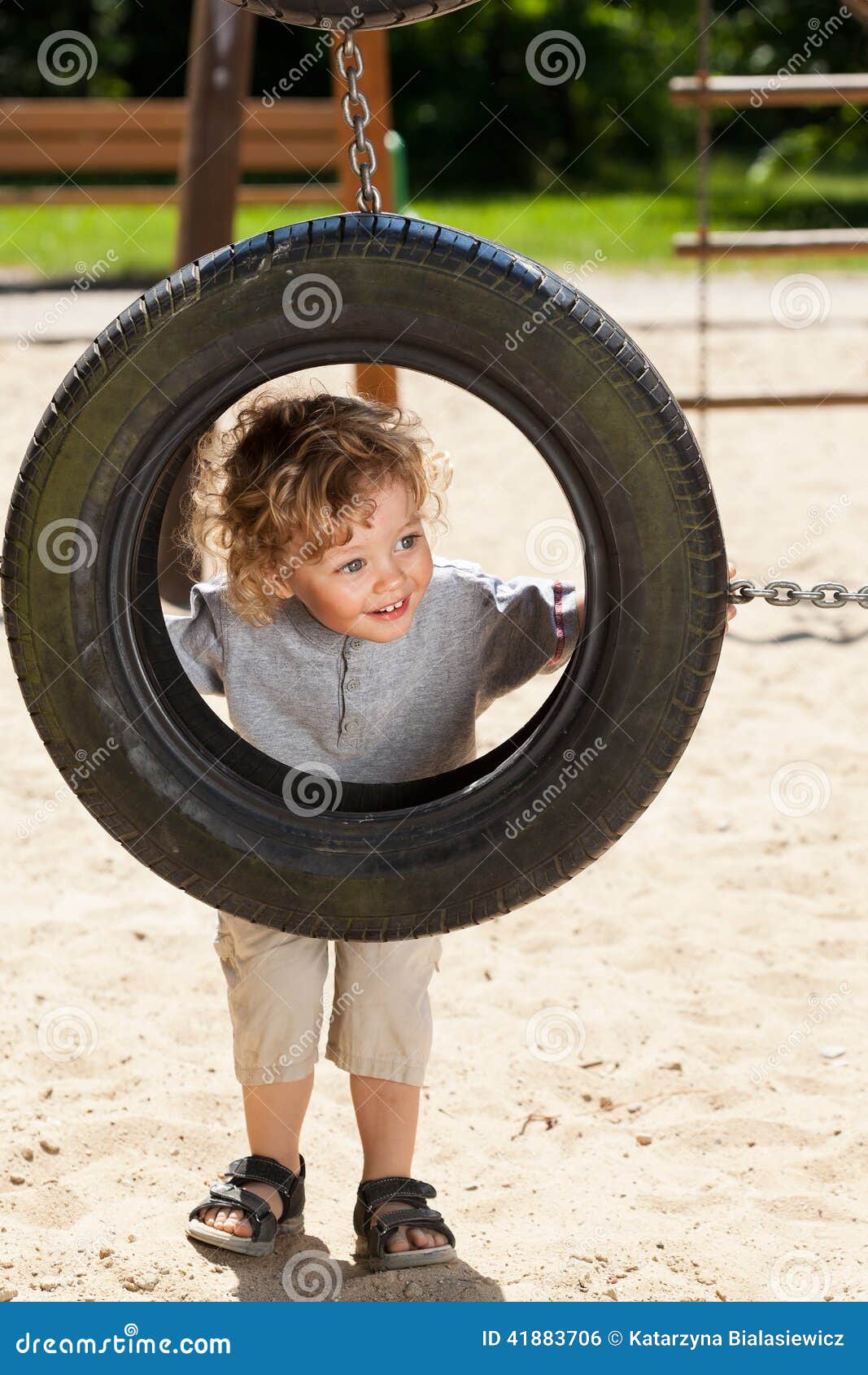Boy Looking through Tire Swing Stock Photo - Image of enjoyment, child ...