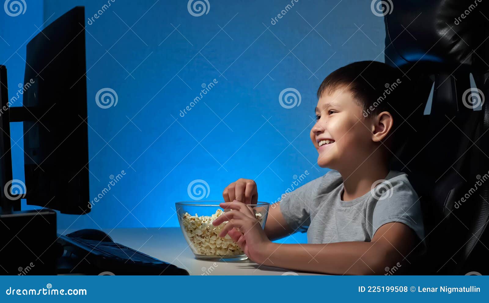 Boy Looks at the Computer Funny Video and Eats Popcorn Stock Photo ...