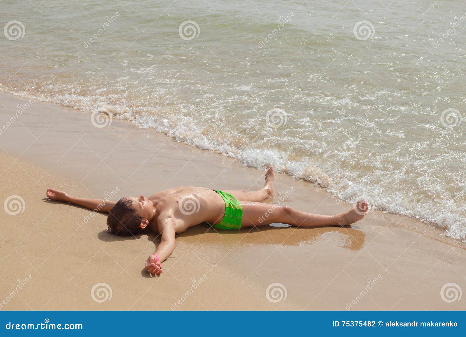 Boy Lying on the Beach and Sunning Stock Photo - Image of young, happy: 75375482