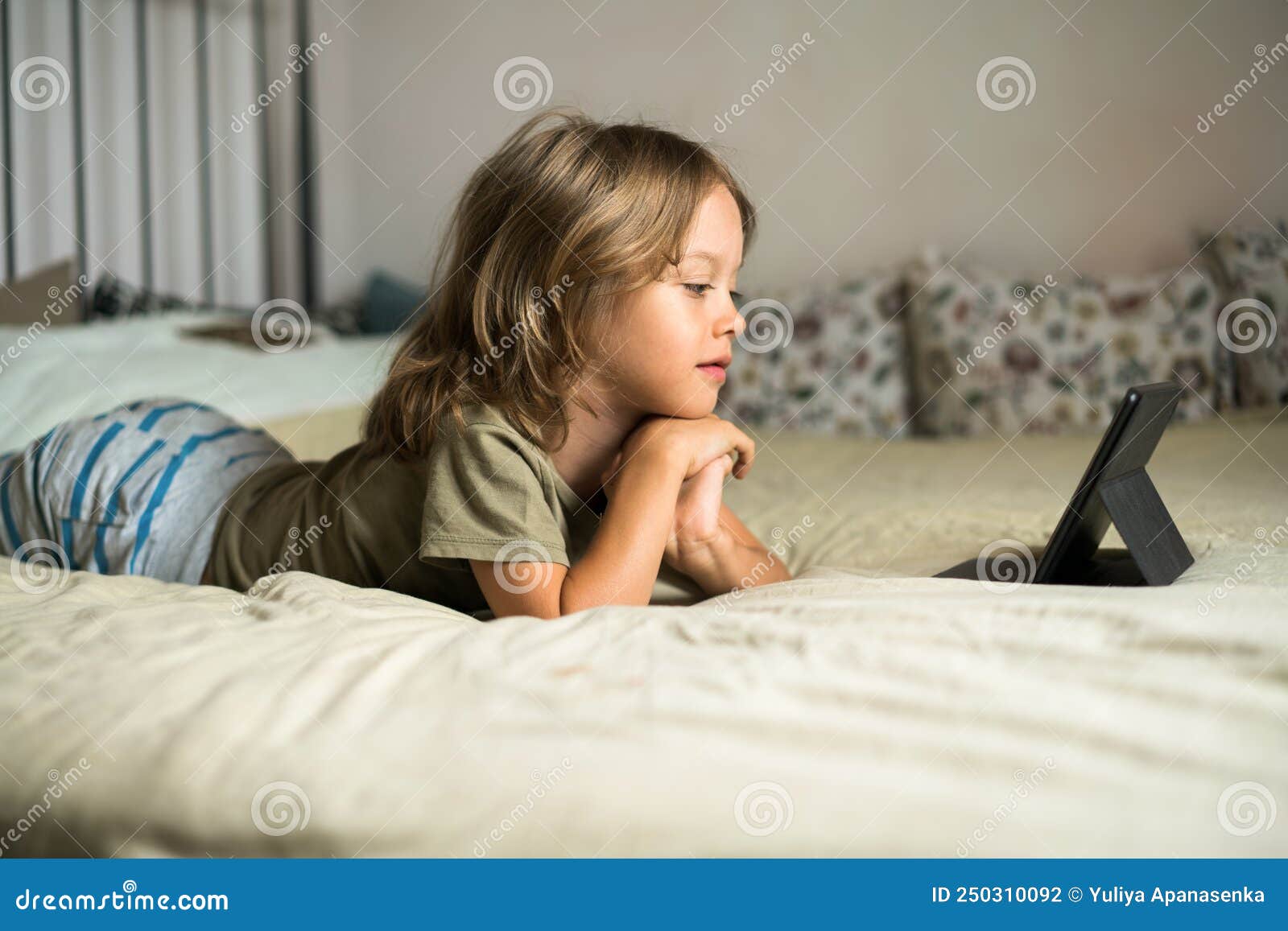 Boy Lying on the Bed Using Digital Tablet Computer Playing Games or ...