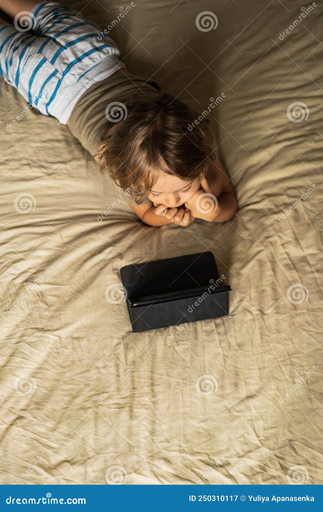 Boy Lying on the Bed Using Digital Tablet Computer Playing Games or ...
