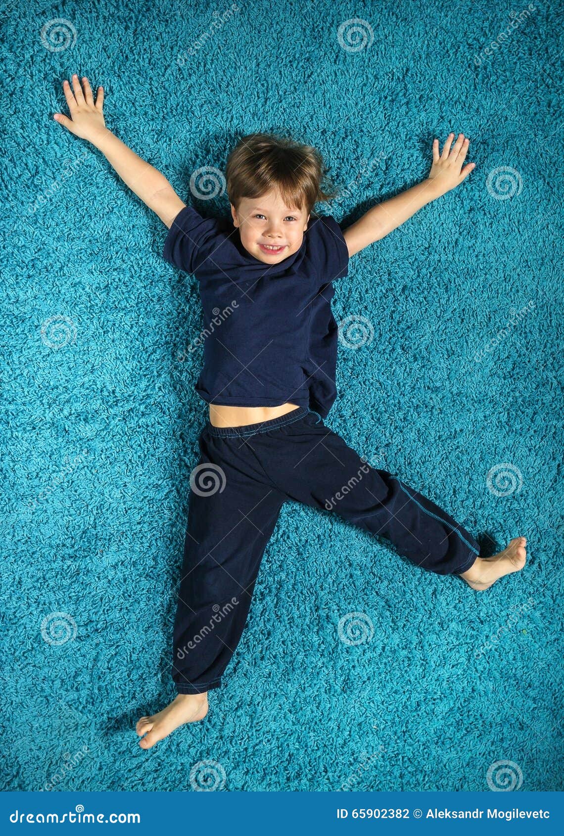 Boy lying on the carpet stock photo. Image of little - 65902382