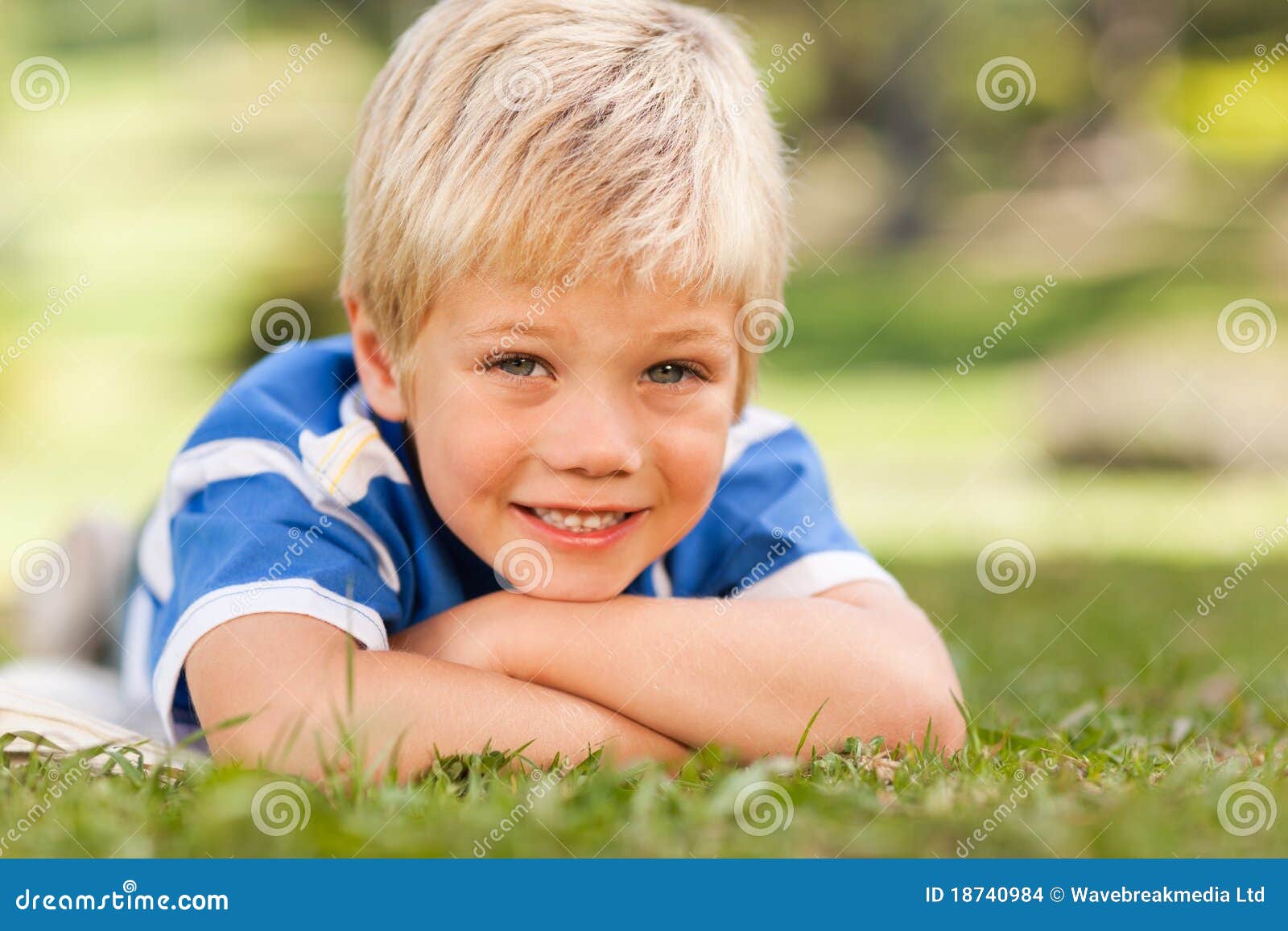 Boy lying down in the park stock photo. Image of cute - 18740984