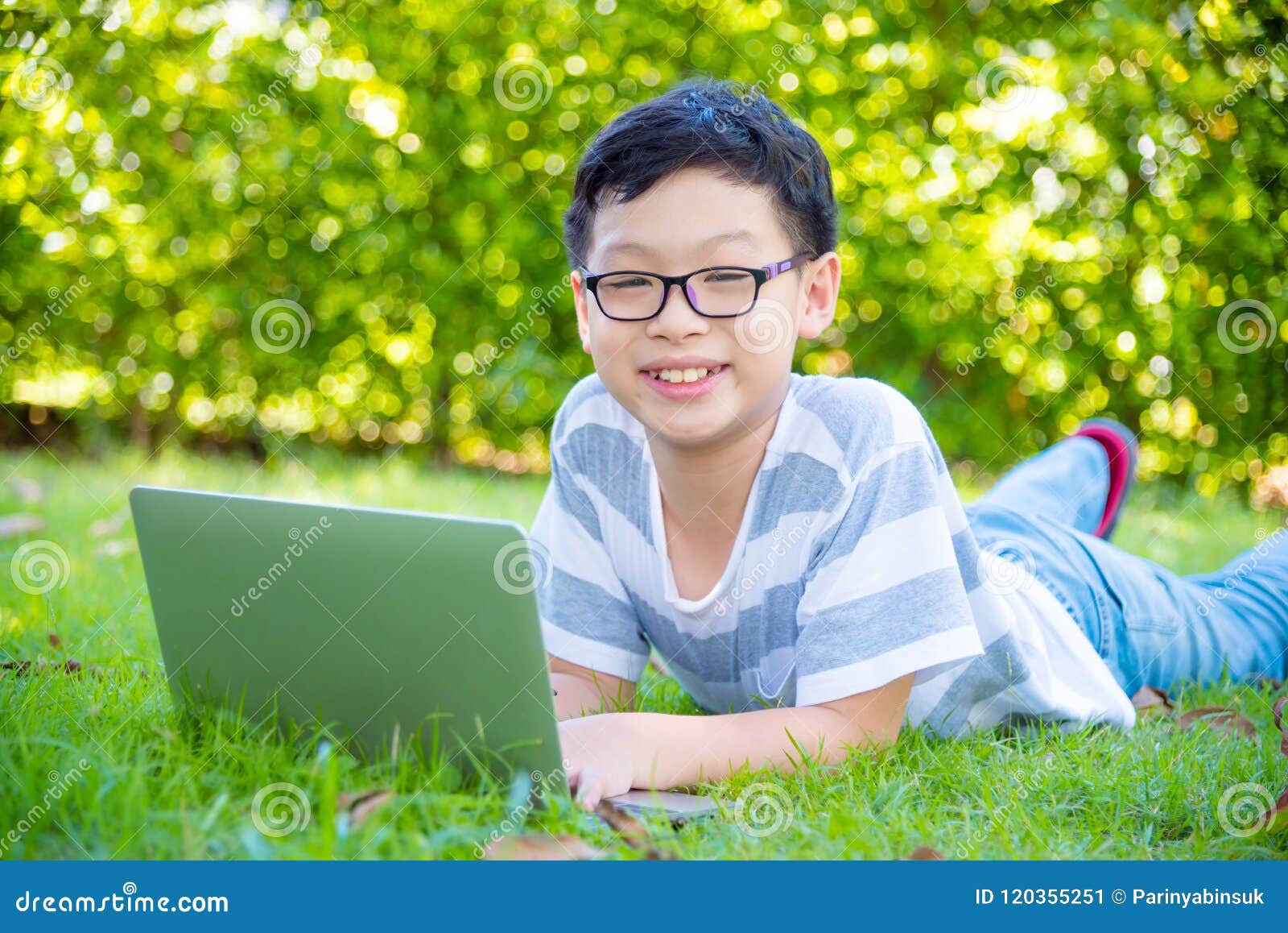 Boy Lying on Grass Field and Using Laptop Computer Stock Image - Image ...