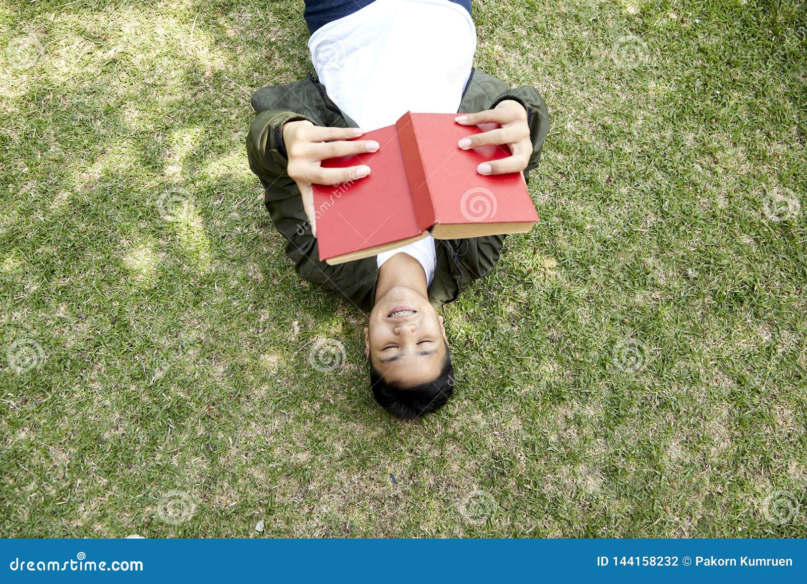 Boy Lying Reading Red Book on Green Grass Stock Photo - Image of asian ...