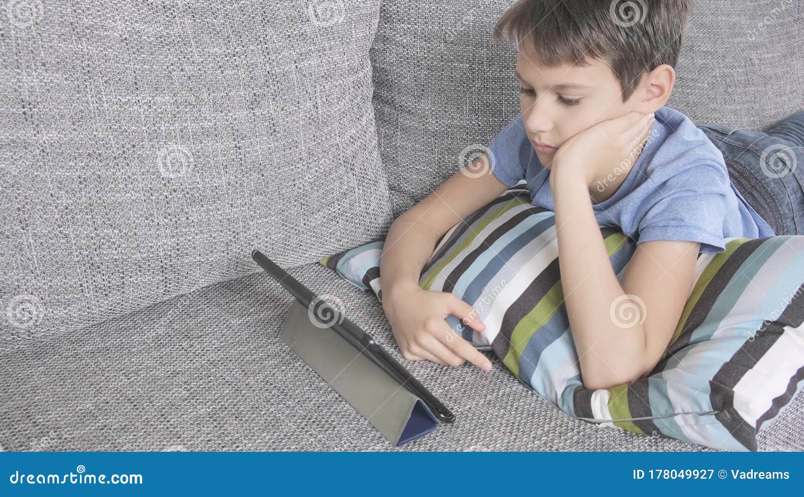 Boy Lying on Sofa with Digital Tablet Computer at Home. Technology ...