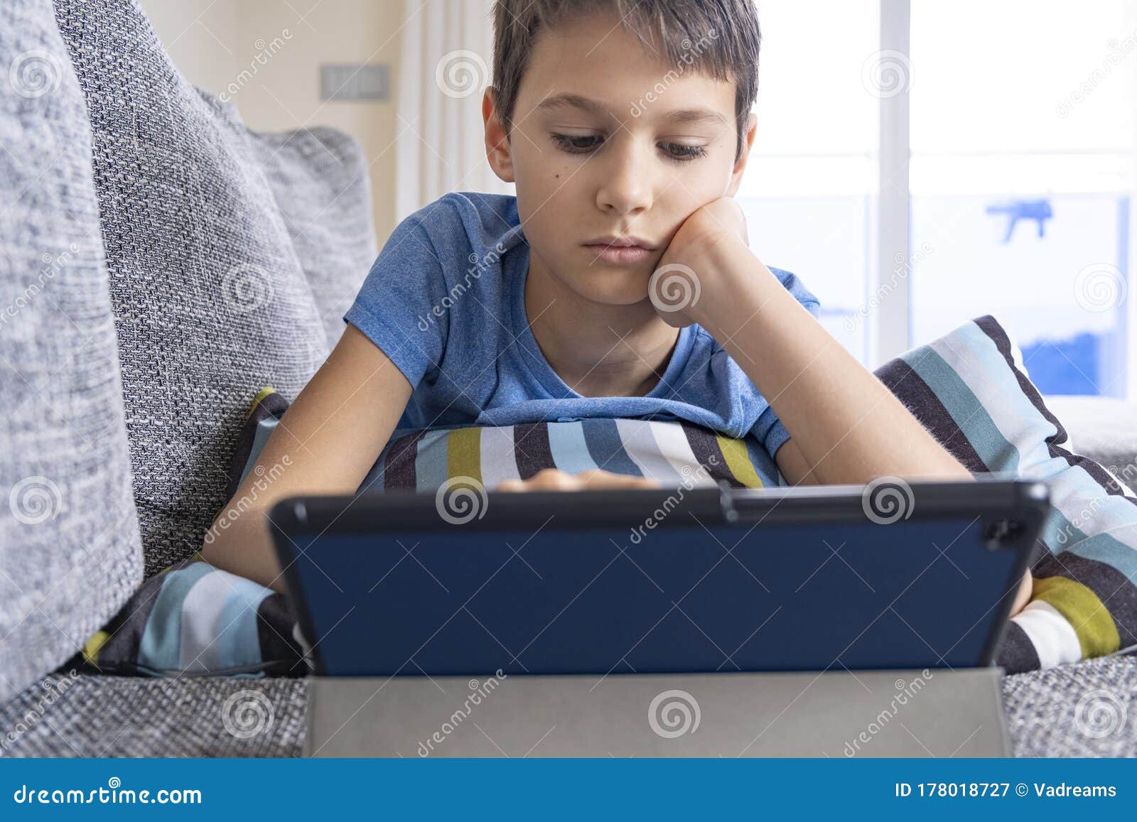Boy Lying on Sofa with Digital Tablet Computer at Home. Technology ...