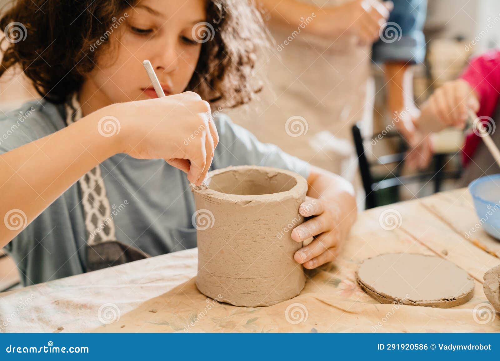 Boy Making Clay Handicrafts while Sitting at Table in Pottery Workshop ...