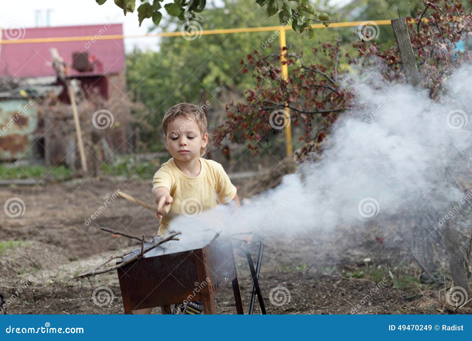 Boy making fire in a grill stock image. Image of fire - 49470249