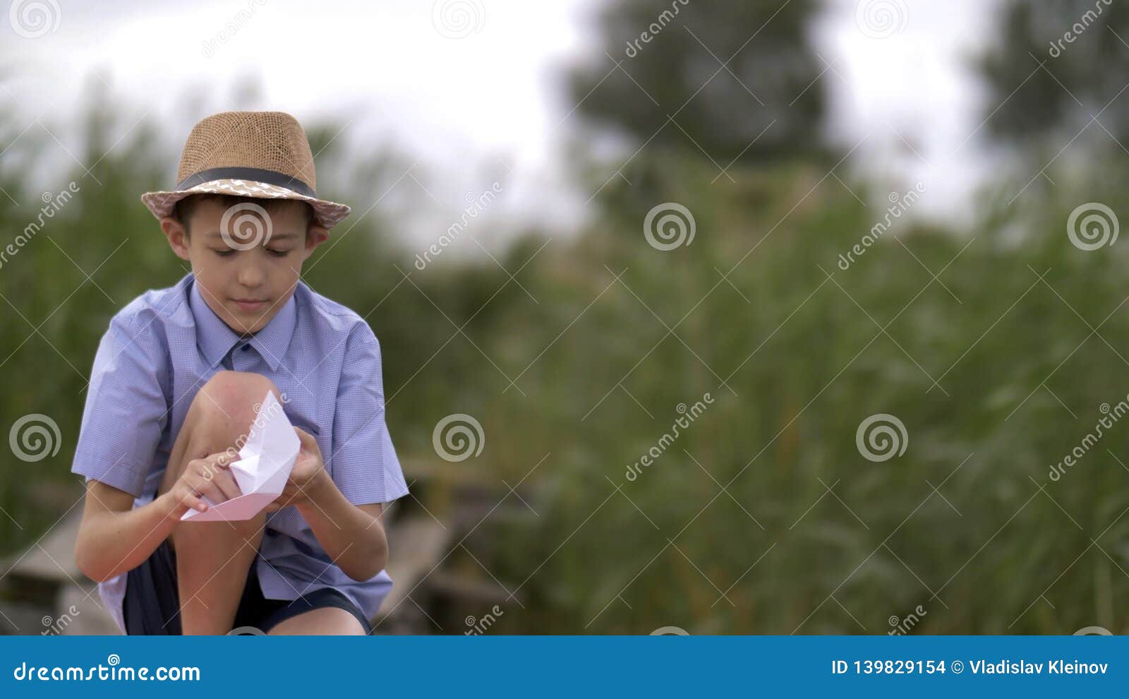 Boy is Making a Paper Boat on Nature, is Preparing To Launch it into ...