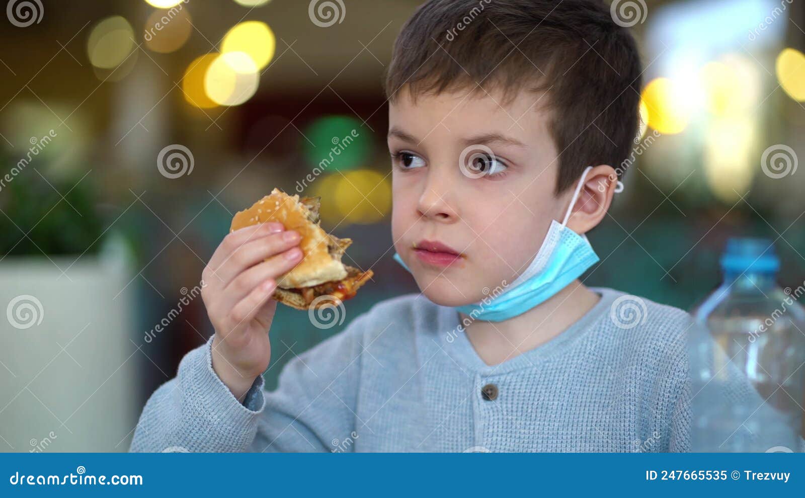 Boy with Medical Mask Eats a Burger with Cutlet Sitting in Restaurant ...