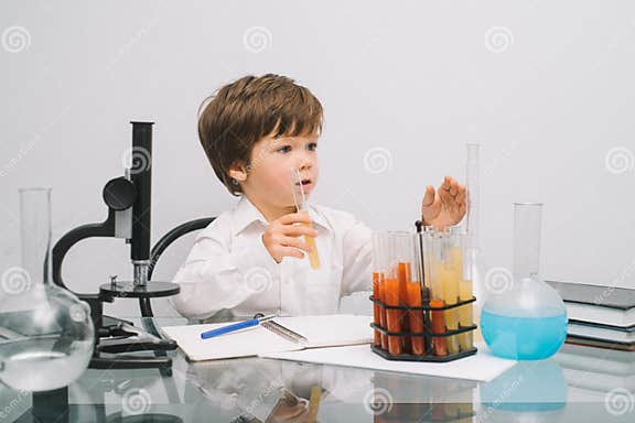The Boy with a Microscope and Various Colorful Flasks on a White ...