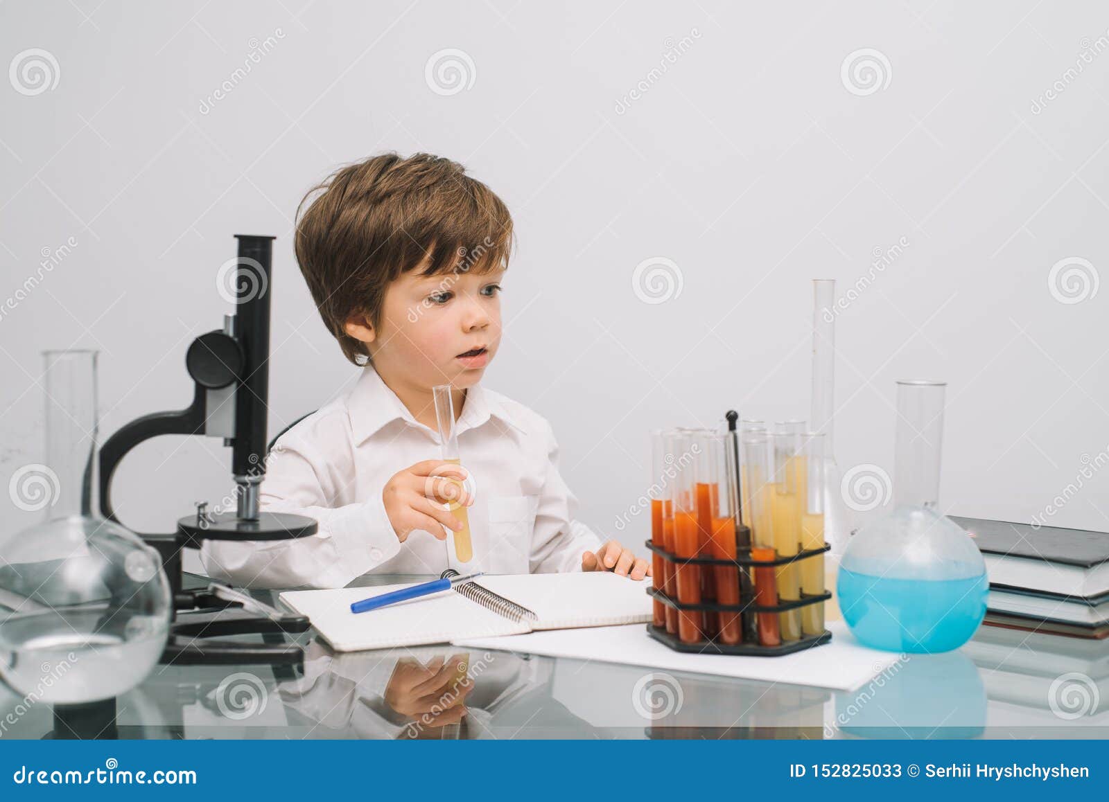 The Boy with a Microscope and Various Colorful Flasks on a White ...