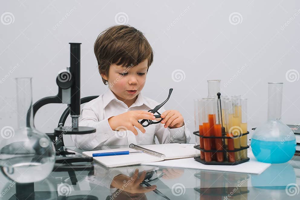 The Boy with a Microscope and Various Colorful Flasks on a White ...