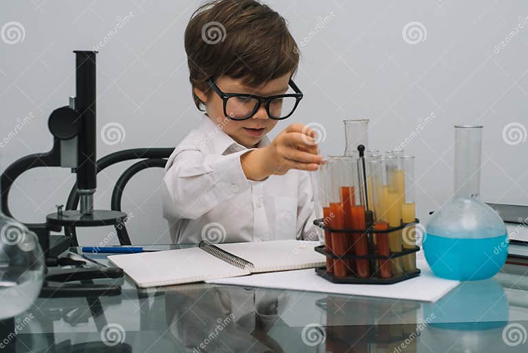The Boy with a Microscope and Various Colorful Flasks on a White ...