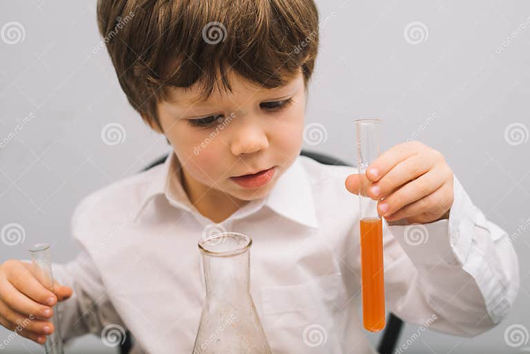 The Boy with a Microscope and Various Colorful Flasks on a White ...