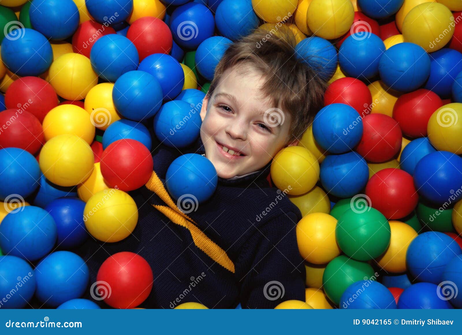 Boy in Multi-coloured Balls Stock Image - Image of colored, yellow: 9042165