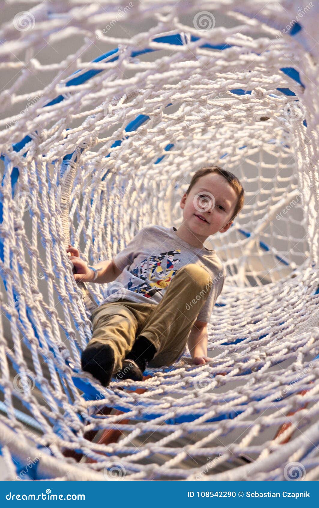 Boy in Net Sleeve of Amusement Park Climbing Facility Stock Photo ... Boy in Net Sleeve of Amusement Park Climbing Facility Stock Photo ...