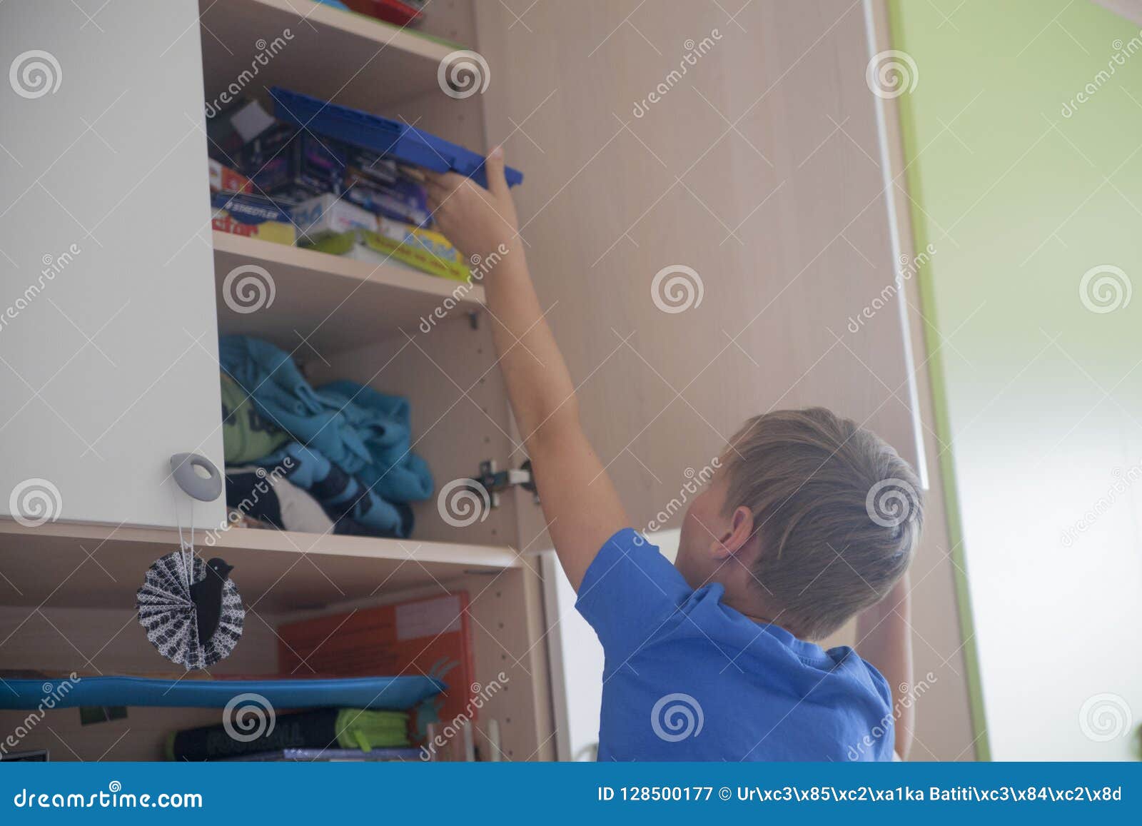 Boy organizing his bedroom stock image. Image of chores - 128500177
