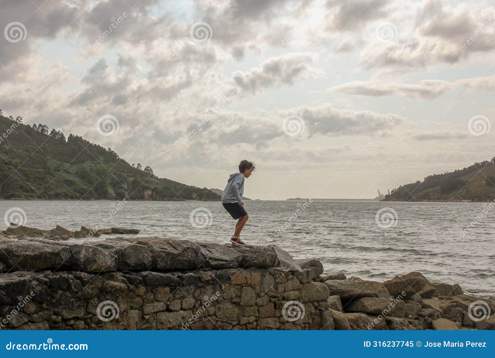 Boy Over a Stone Wall in a Beach Stock Image - Image of nature, colored ...