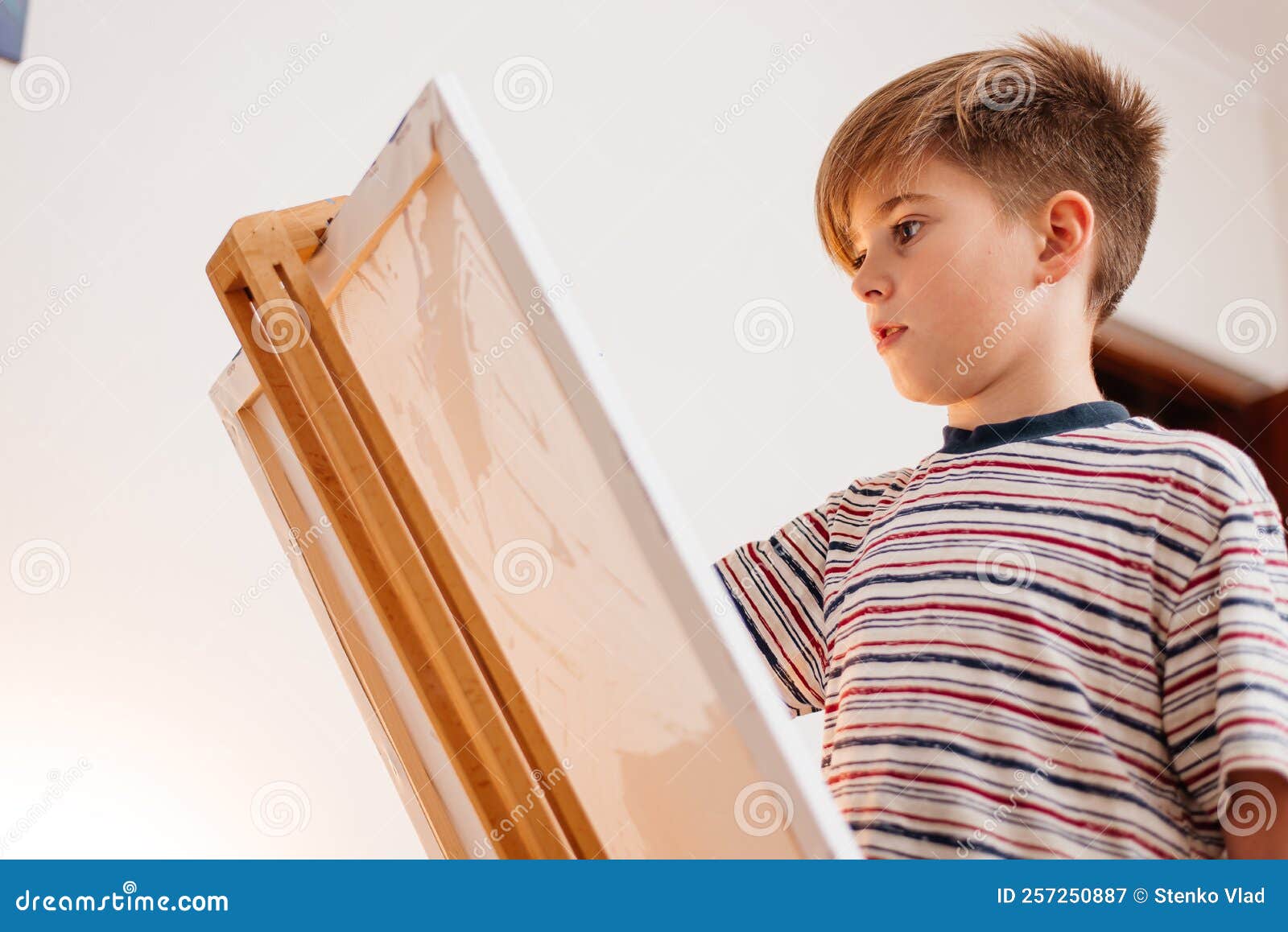 A Boy Paints a Picture on Canvas with a Brush and Paints Stock Image ...