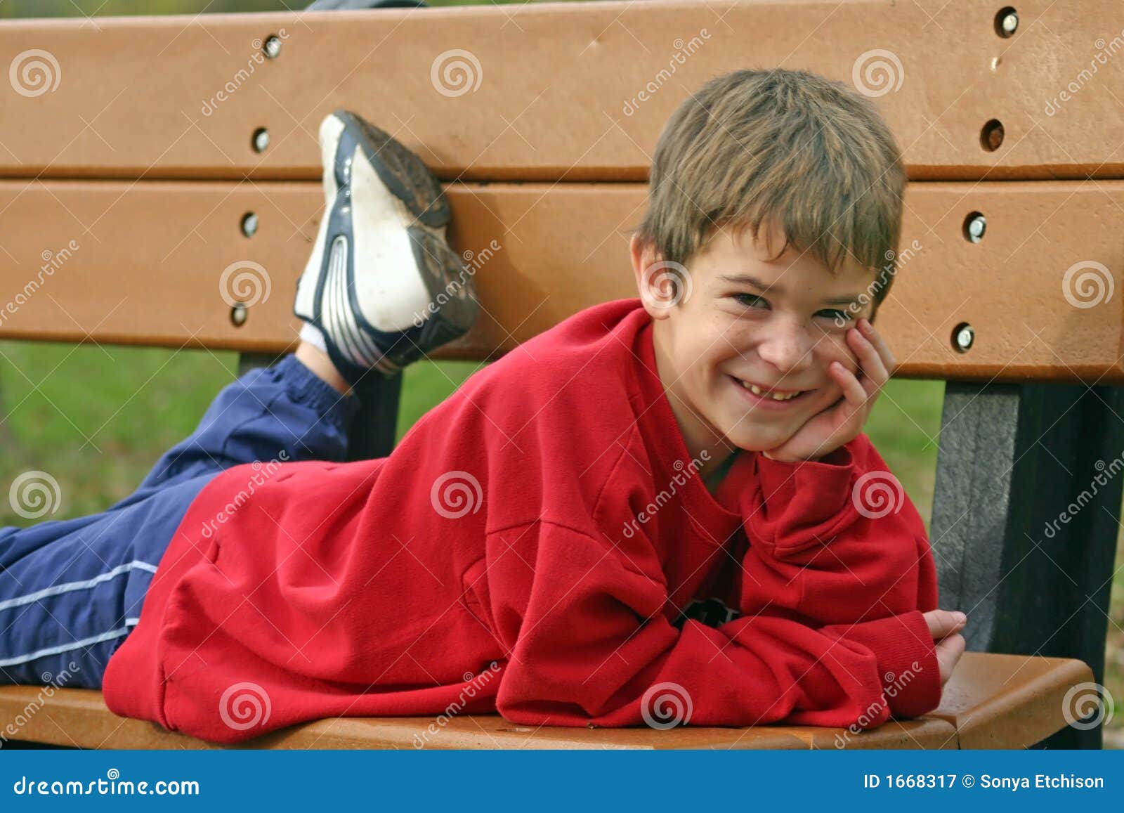 Boy on Park Bench stock image. Image of smiling, face - 1668317
