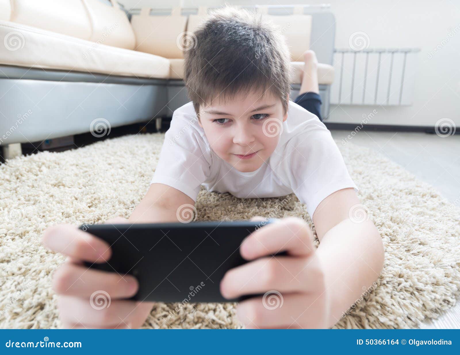 Boy with Phone Lying on a Carpet in the Room Stock Photo - Image of ...