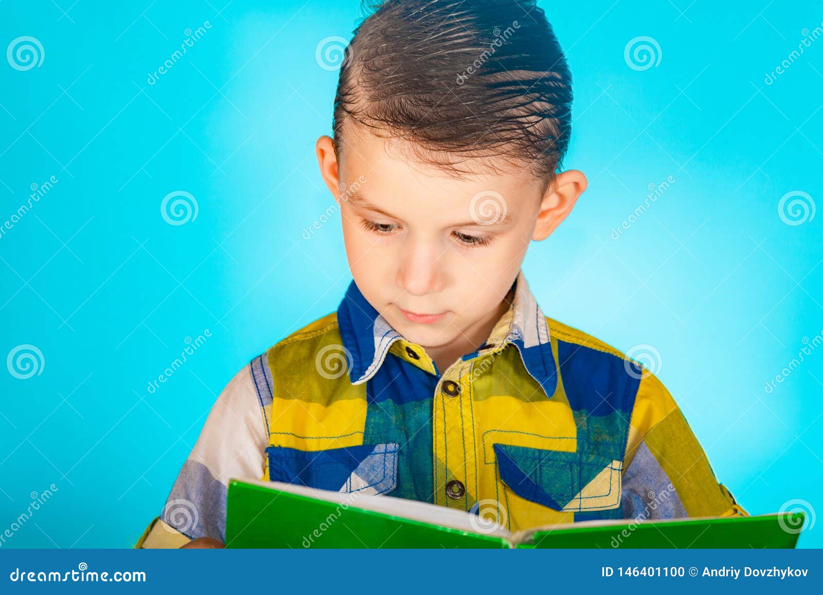 A Boy in a Plaid Shirt Reading a Book on a Blue Background Stock Photo ...