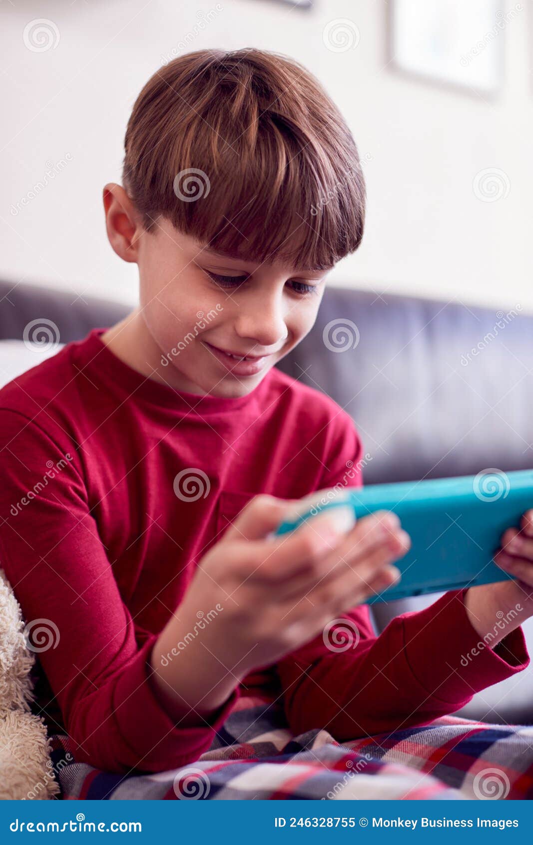 Boy Playing Computer Game on Portable Gaming Device at Home Wearing ...