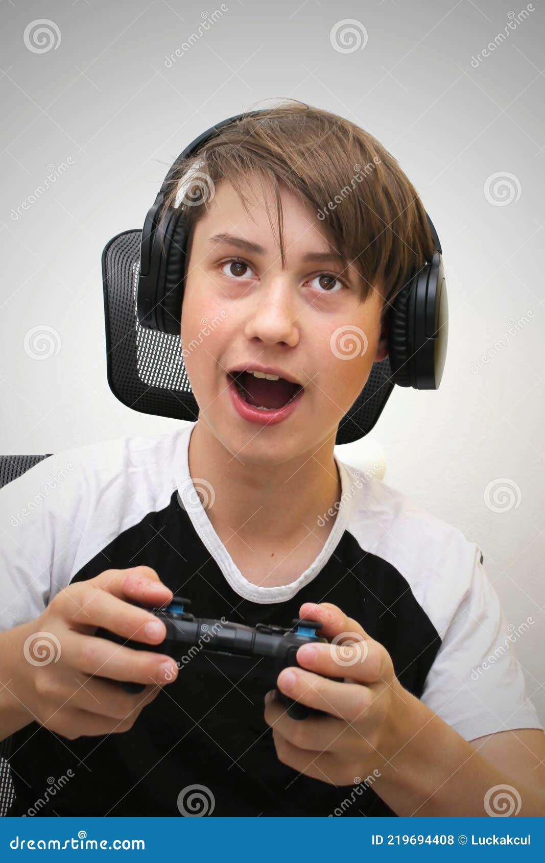 The Boy is Playing a Computer Game and Sitting on a Gaming Chair. Stock ...