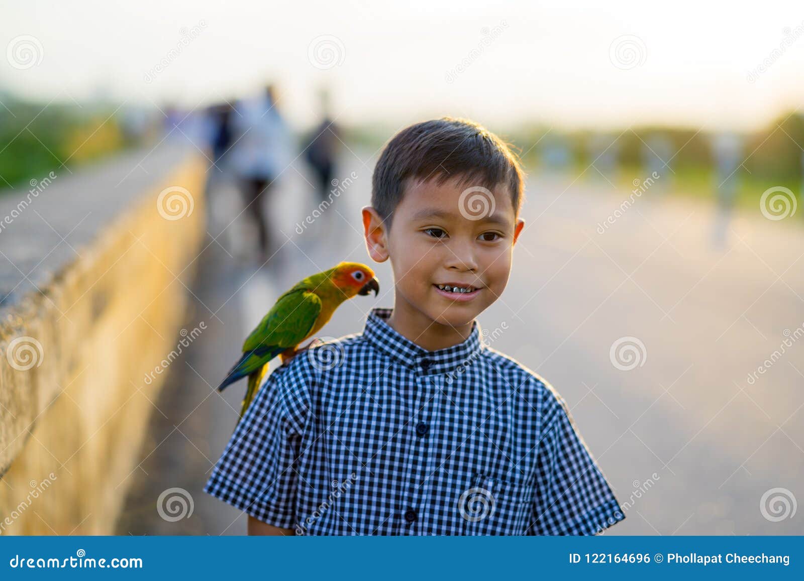 The Boy Playing with the Parrot on His Shoulders. Stock Photo - Image ...