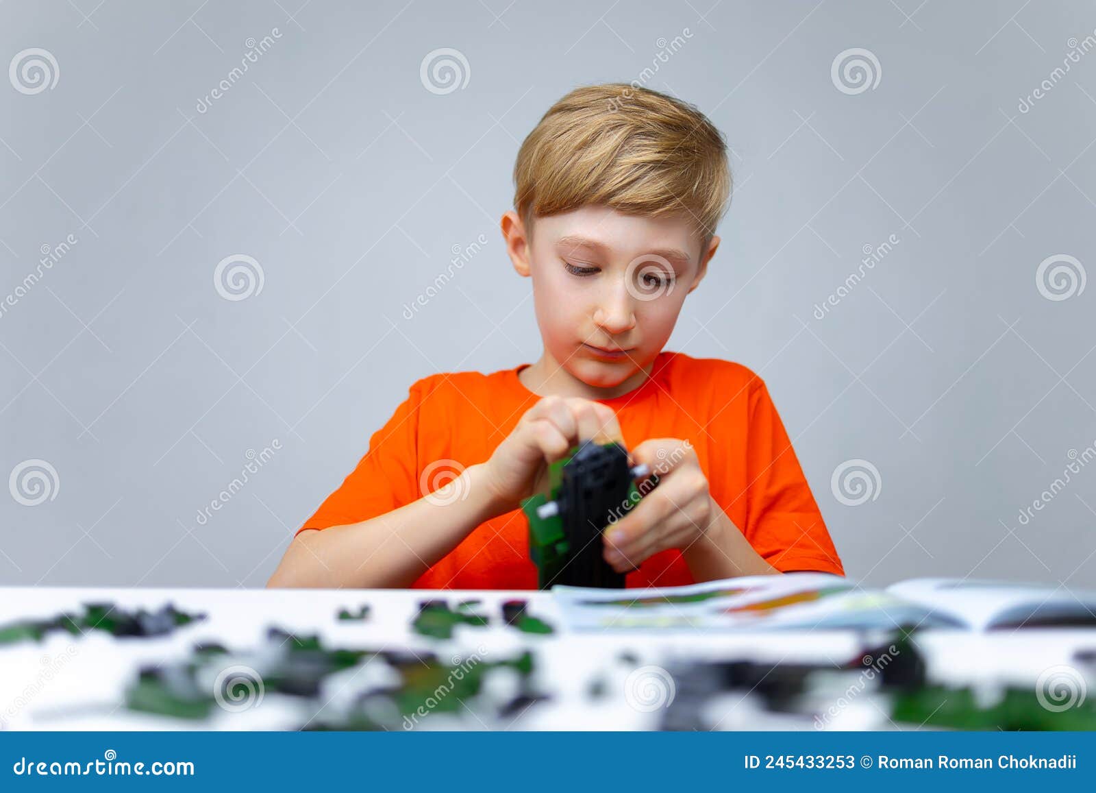 The Boy is Playing with a Plastic Constructor, he is Attaching the ...