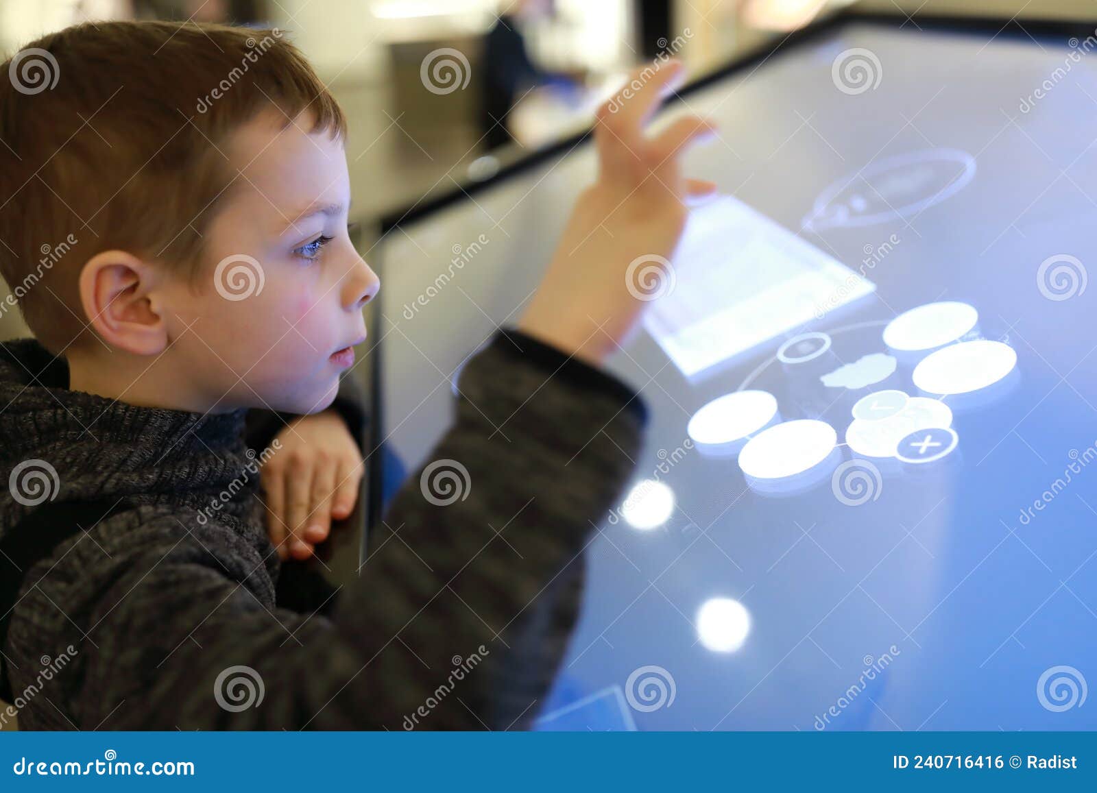Boy Playing Puzzles on Touch Screen in Entertainment Center Stock Photo ...