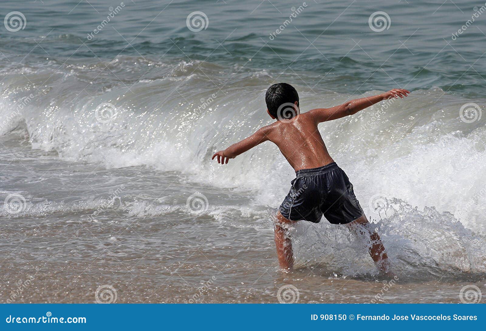 Boy playing in the sea stock photo. Image of sand, playful - 908150