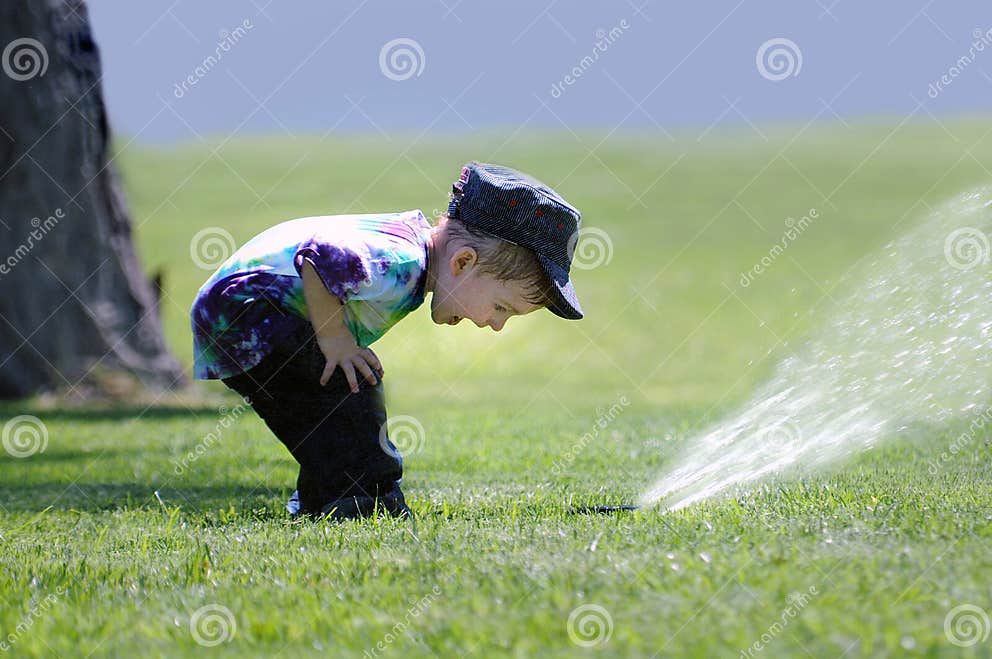 Boy Playing with Sprinkler stock photo. Image of childhood - 8299386
