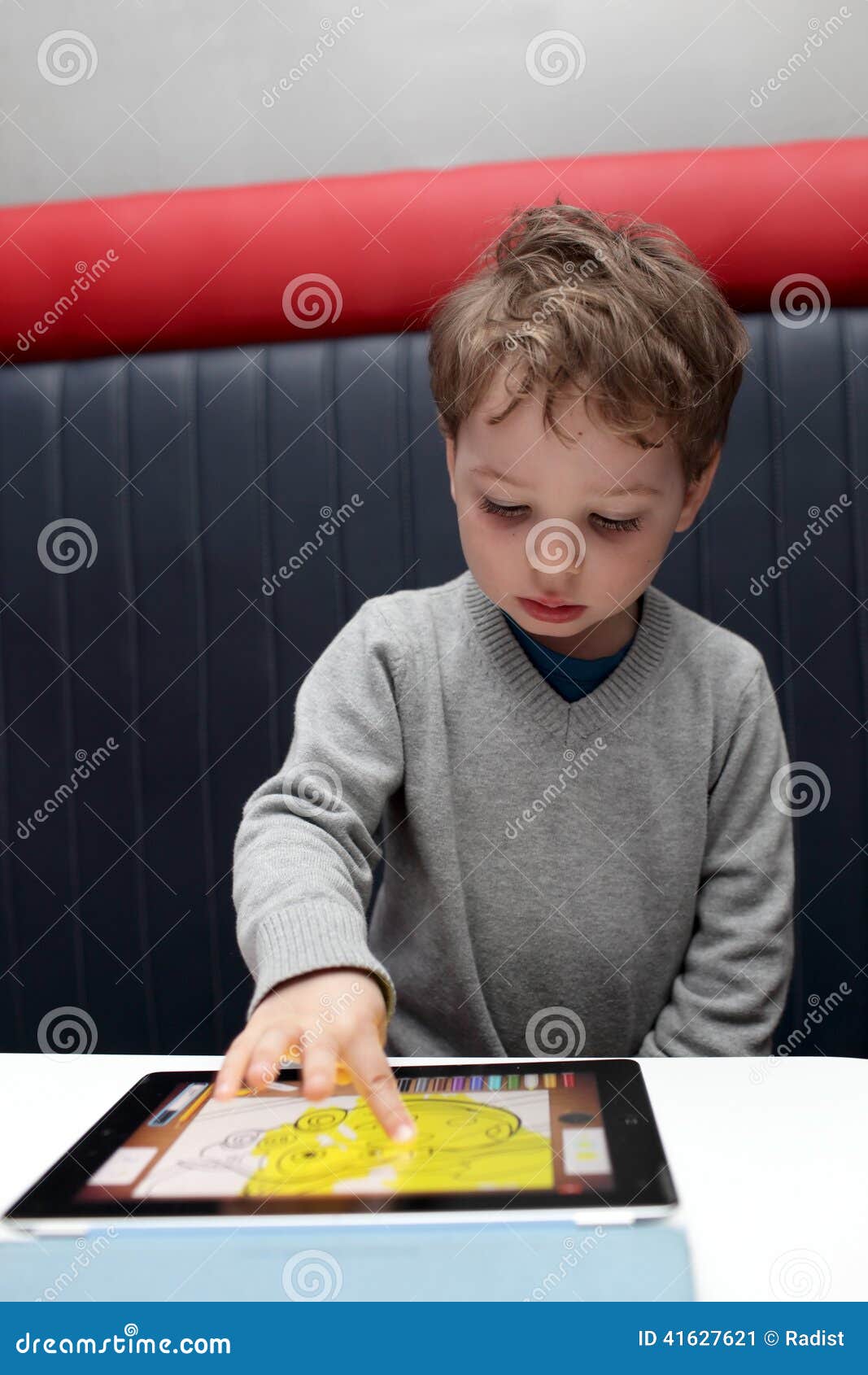 Boy playing with tablet PC stock image. Image of indoors - 41627621