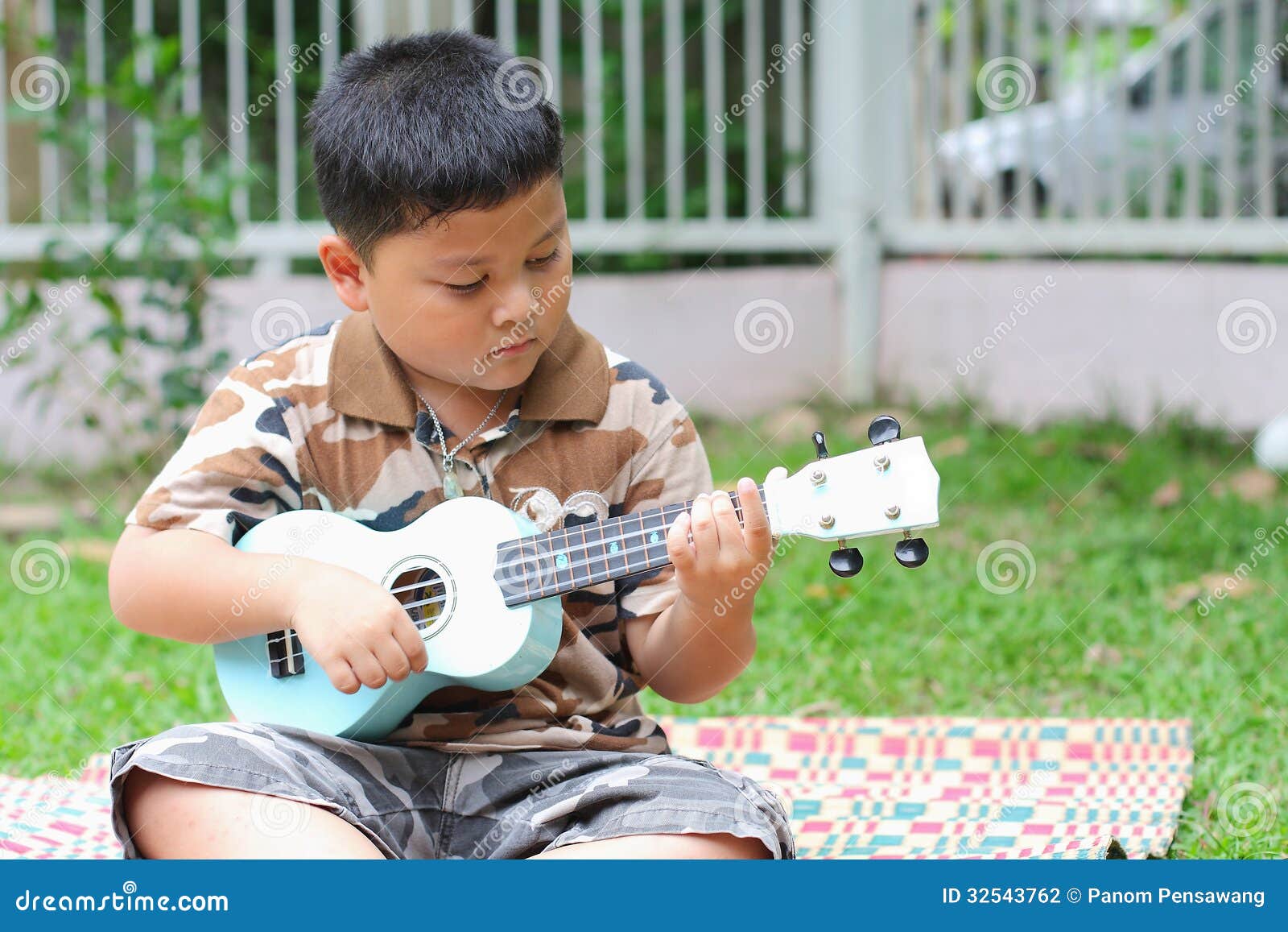 Boy playing the ukulele stock photo. Image of education - 32543762
